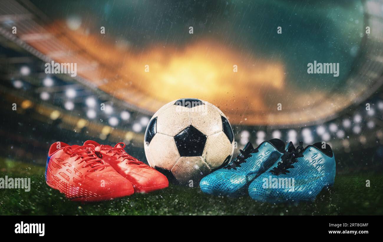 Two pairs of soccer shoes and a ball on the ground as a sign of ...
