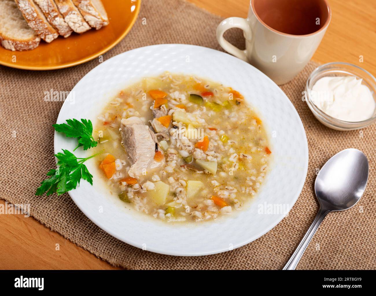 Traditional Russian thick sour soup rassolnik served with a piece of ...