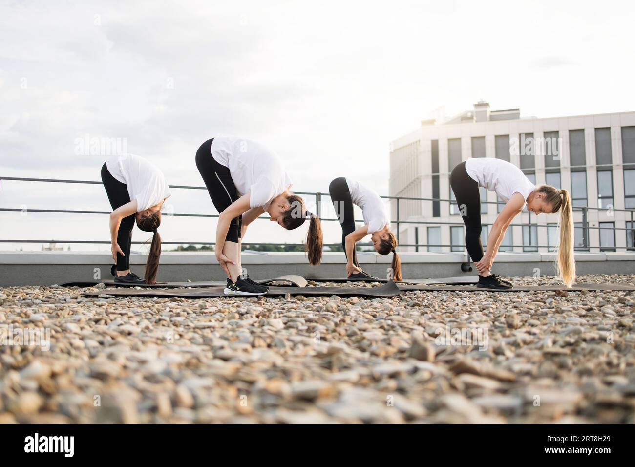 Ladies in activewear bending forward during outdoor exercise Stock ...