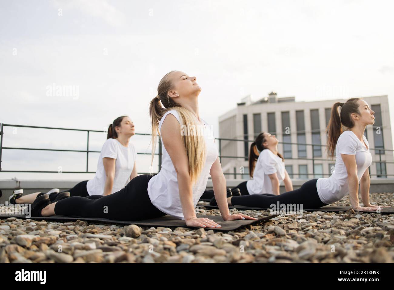 Adults achieving back bending asana during outdoor training Stock Photo ...