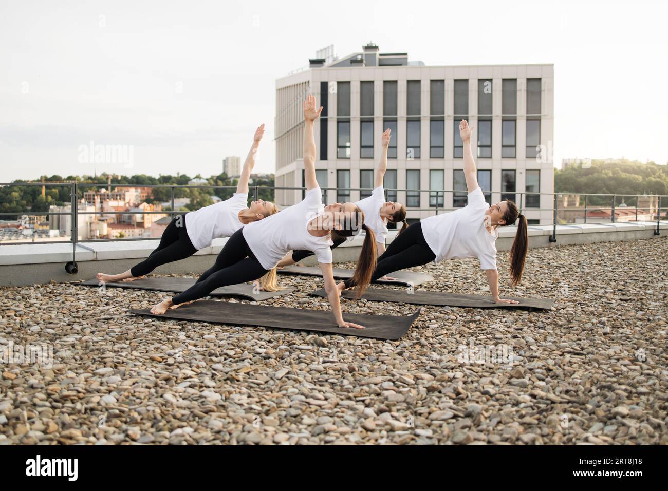 Athletic people balancing in Side Plank Pose in fresh air Stock Photo ...
