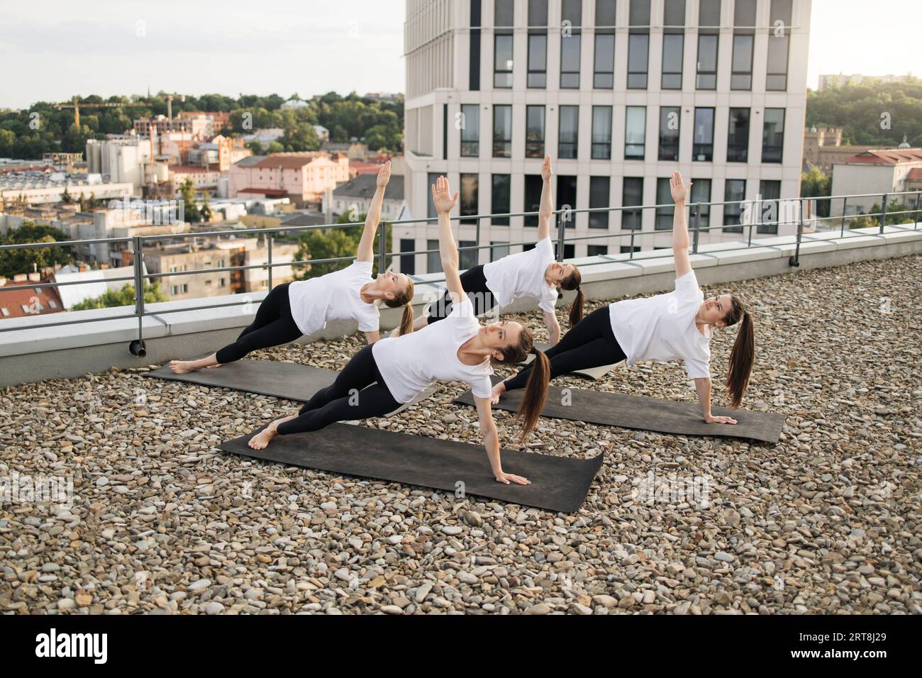 Athletic people balancing in Side Plank Pose in fresh air Stock Photo ...