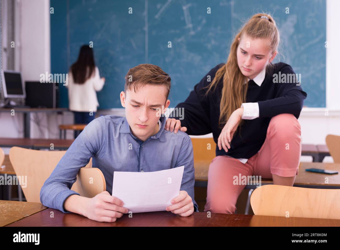 Female classmate calming frustrated teenager Stock Photo - Alamy