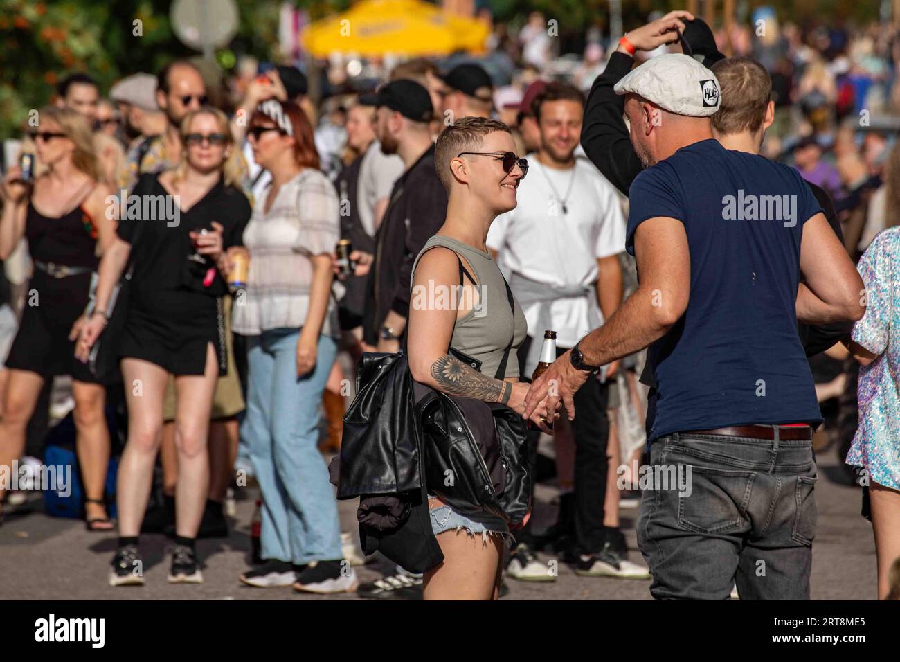 Man and woman chatting in front of large crowd at Kallio Block Party ...
