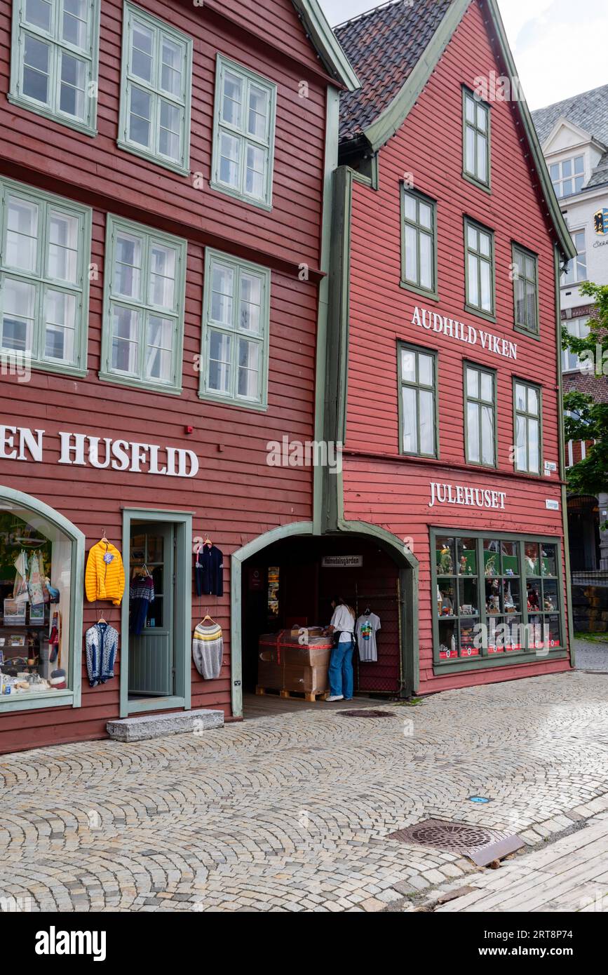 Tourists explore the UNESCO World Heritage site of Bryggen at the Bergen harbor; Bergen, Norway ...