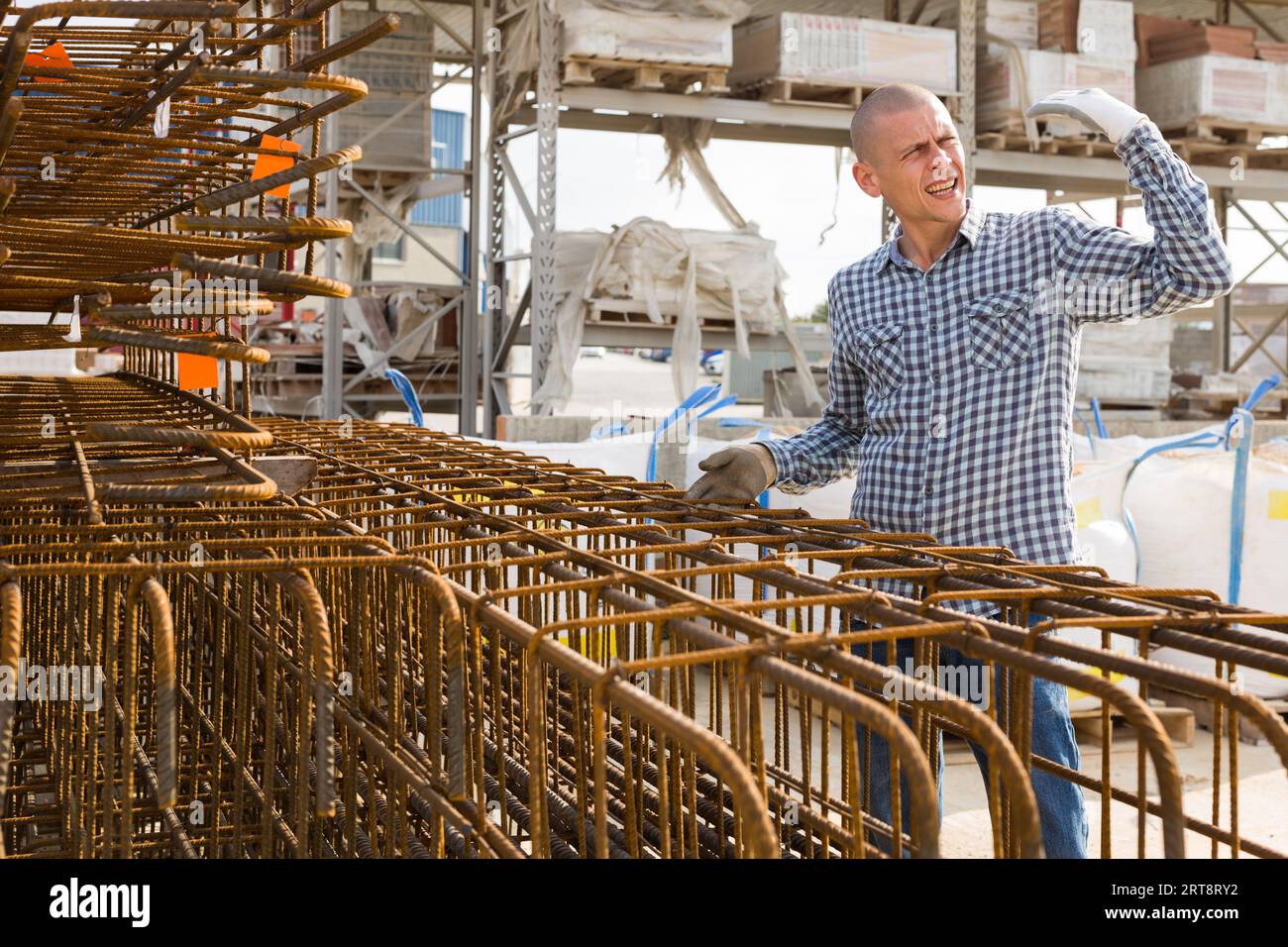 Man worker with reinforcing steel bars during work in warehouse Stock ...