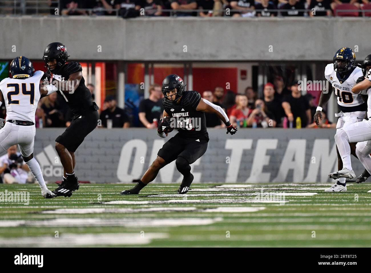 Louisville running back Isaac Guerendo (23) runs through an opening in ...