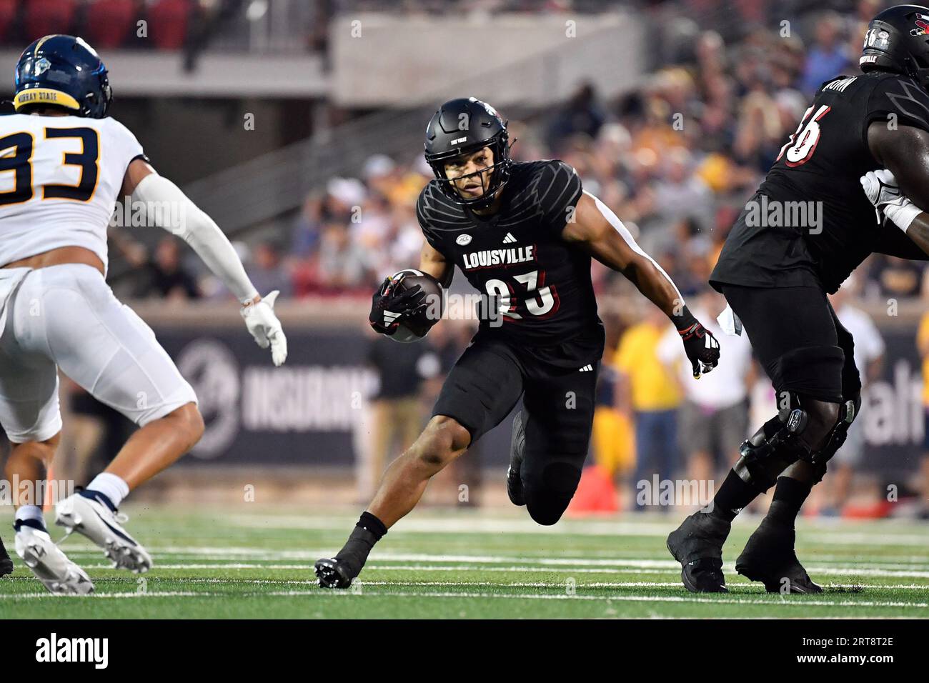 Louisville running back Isaac Guerendo (23) runs through an opening in ...