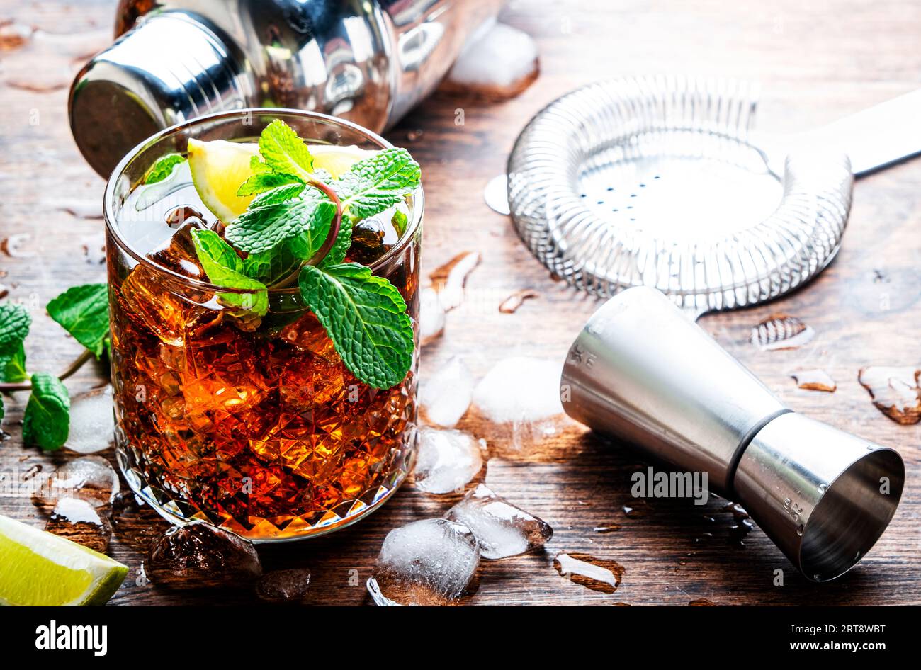 Rum cola cocktail drink with strong alcohol, mint, ice and lime in ...