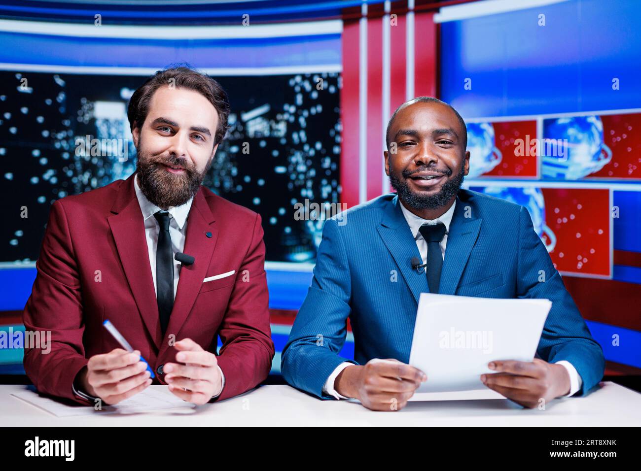 TV hosts presenting live newscast in newsroom, reporting breaking news on night talk show. Two ...