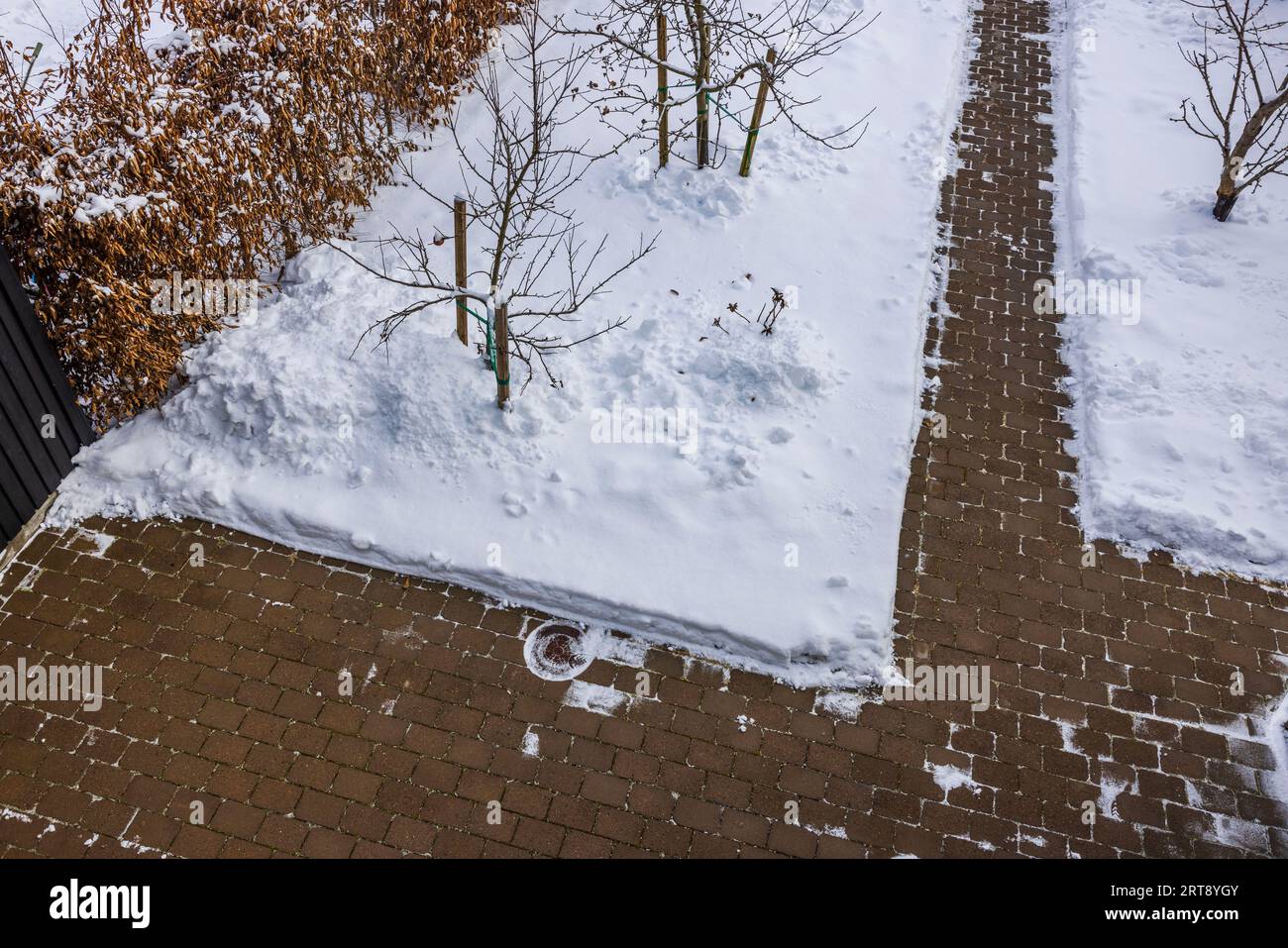Winter view from above of winter garden snow-cleared path made of gray ...