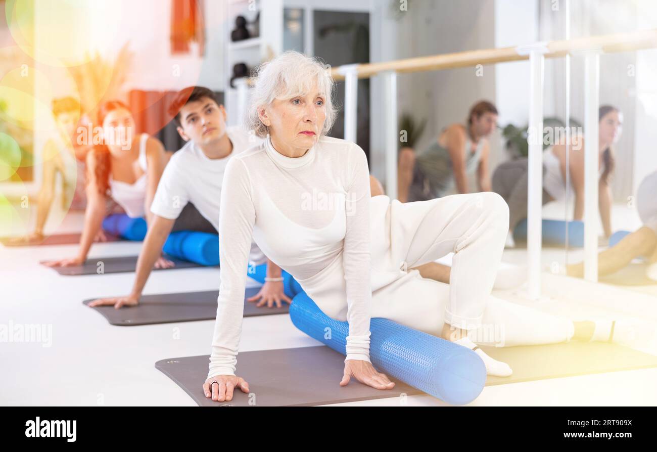 Group of different people doing exercises with roller Stock Photo - Alamy