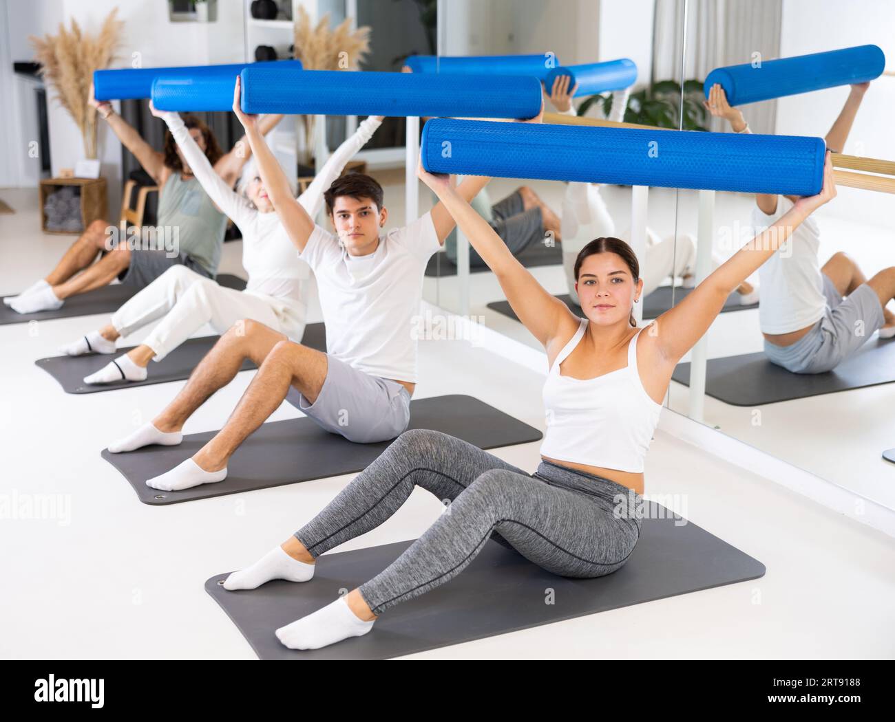 Group of different people doing exercises with roller Stock Photo - Alamy