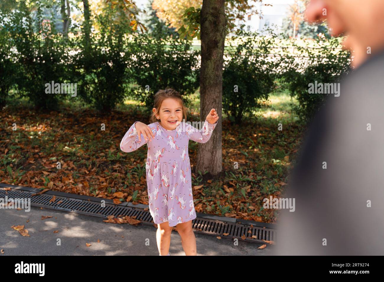 Father and child girl playing Tag chasing game outdoors on the streets ...