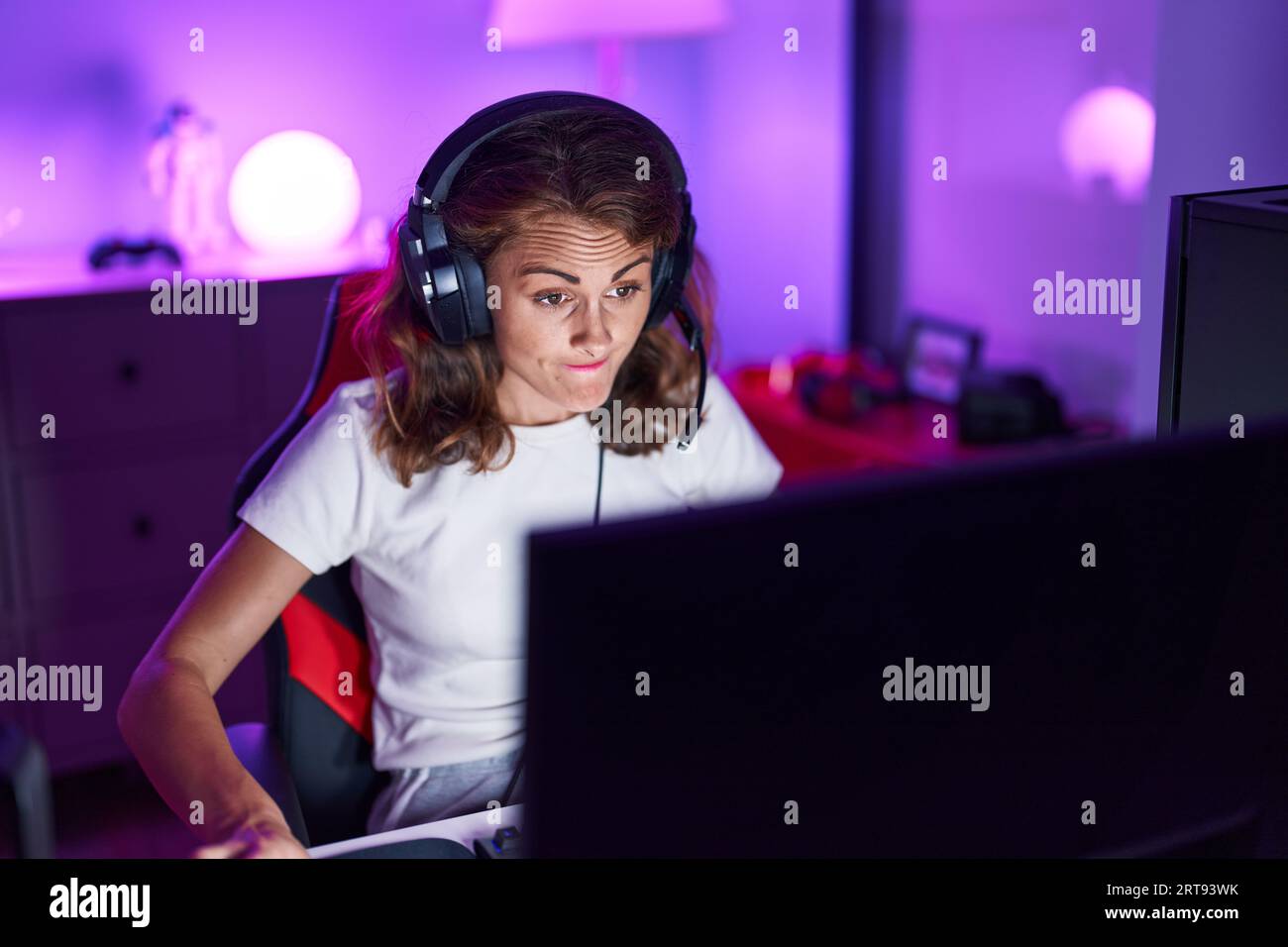 Young beautiful hispanic woman streamer playing video game using ...