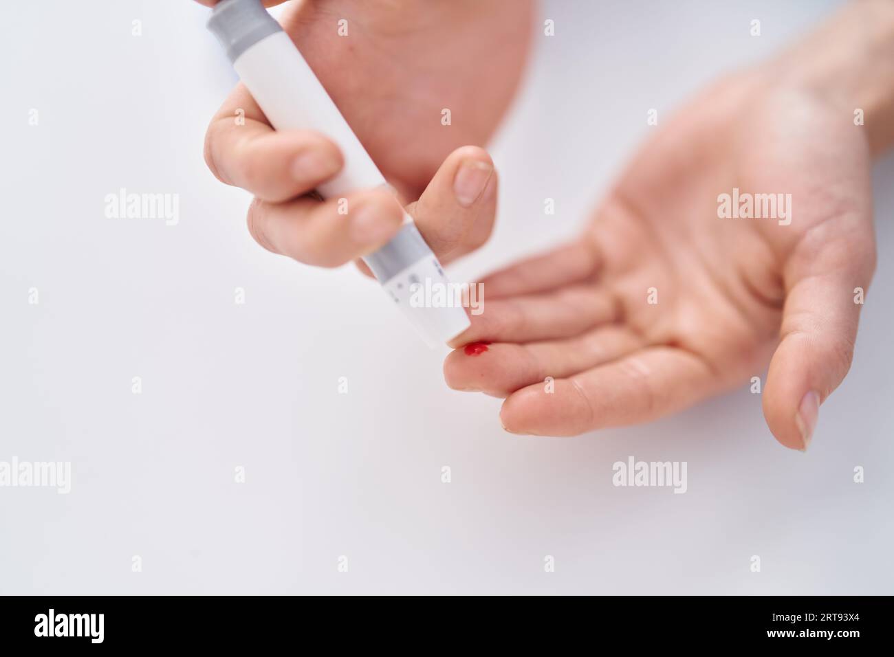 Young woman measuring glucose injecting on finger at home Stock Photo ...