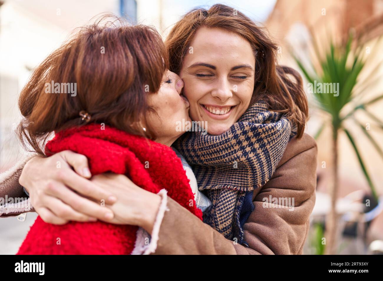 Two women mother and daughter hugging each other kissing at street Stock Photo - Alamy
