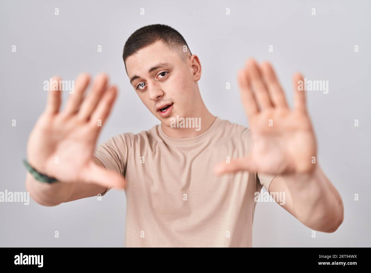 Young man standing over isolated background doing frame using hands ...