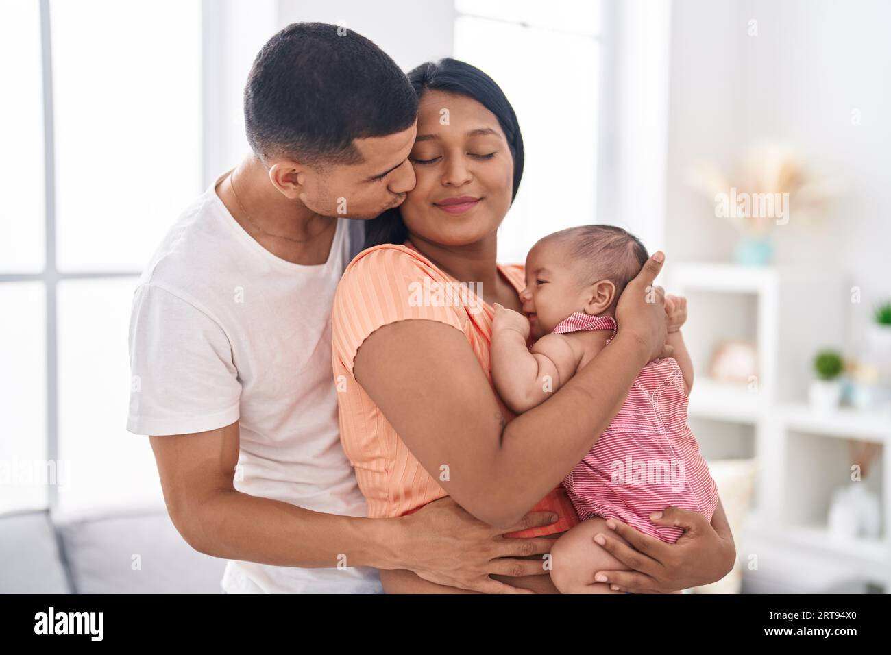 Hispanic family hugging each other kissing at home Stock Photo - Alamy