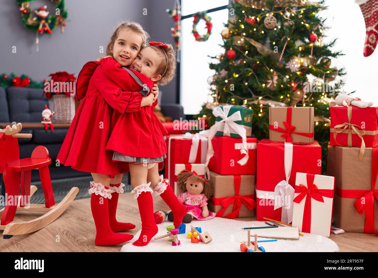 Adorable girls hugging each other celebrating christmas at home Stock ...