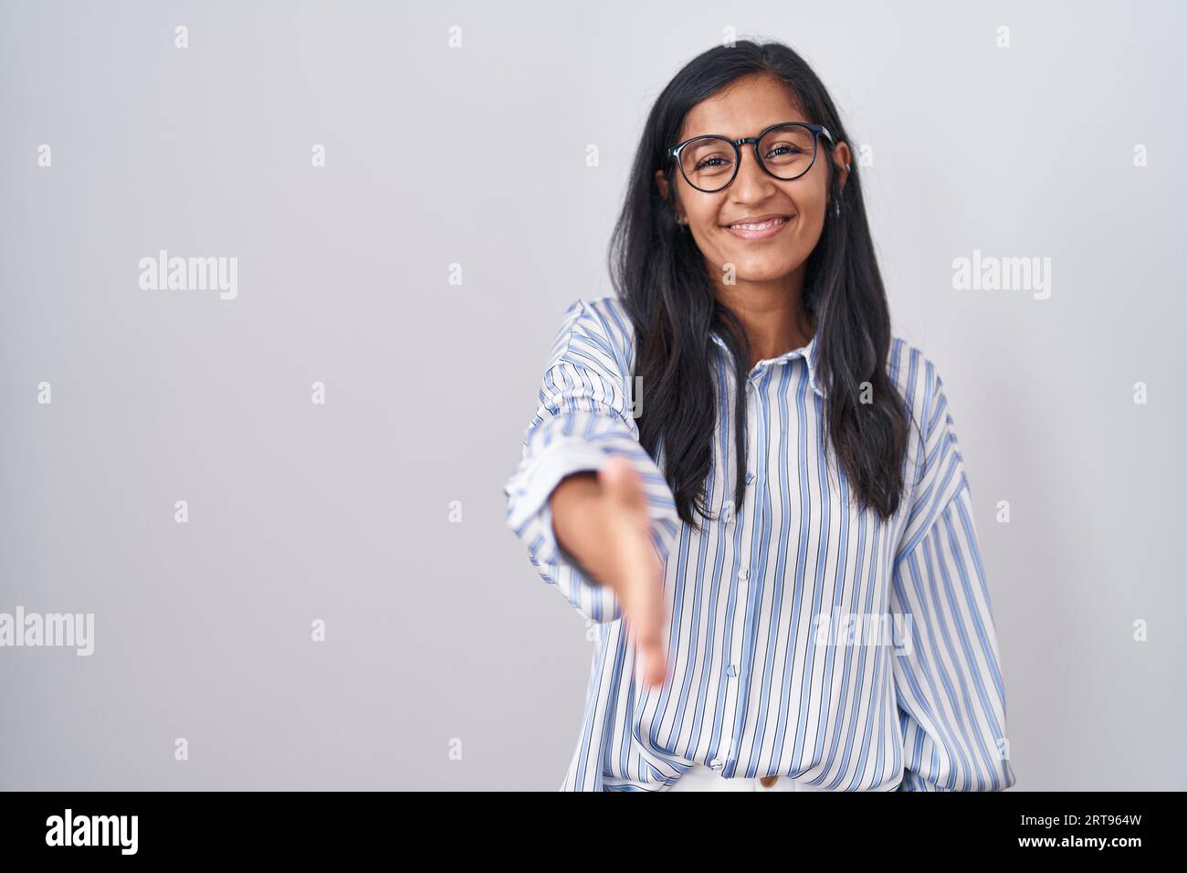 Young hispanic woman wearing glasses smiling friendly offering ...