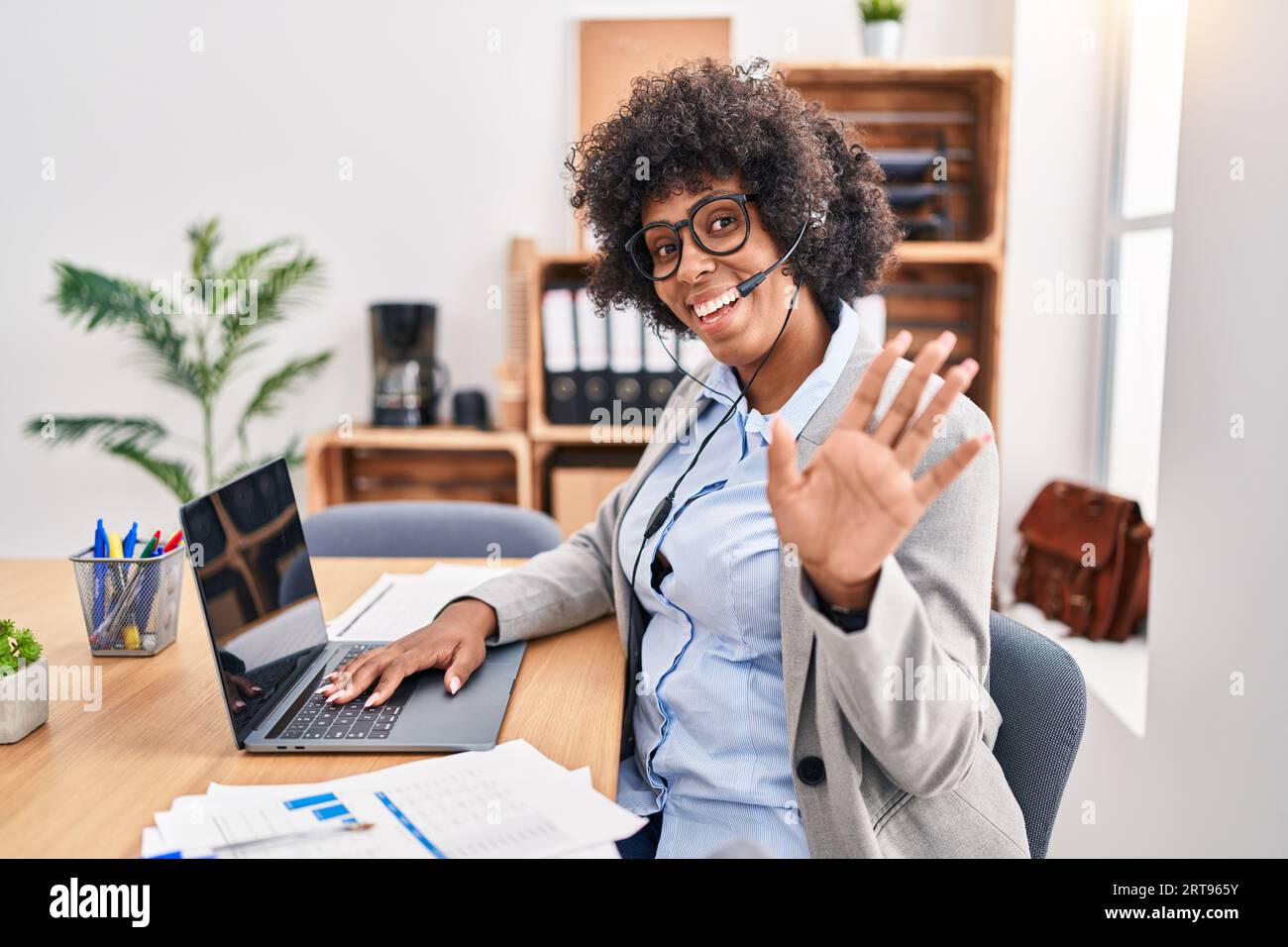 Black woman with curly hair wearing call center agent headset at the ...