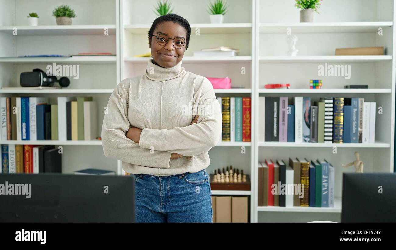 African american woman student smiling confident standing with arms crossed gesture at library ...