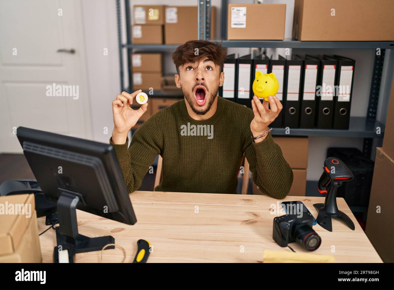 Arab man with beard working at small business ecommerce holding bitcoin ...