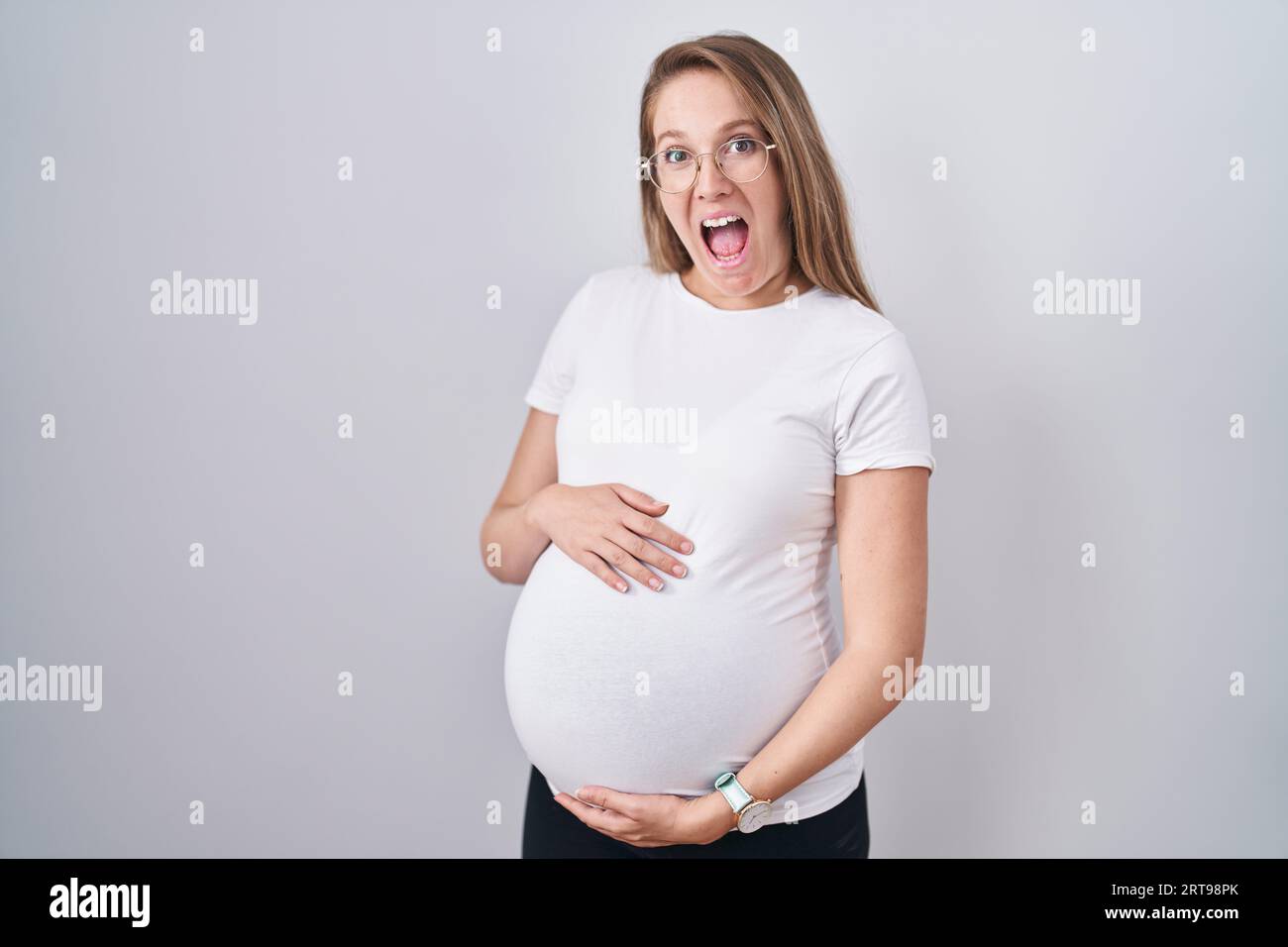 Young pregnant woman expecting a baby, touching pregnant belly ...