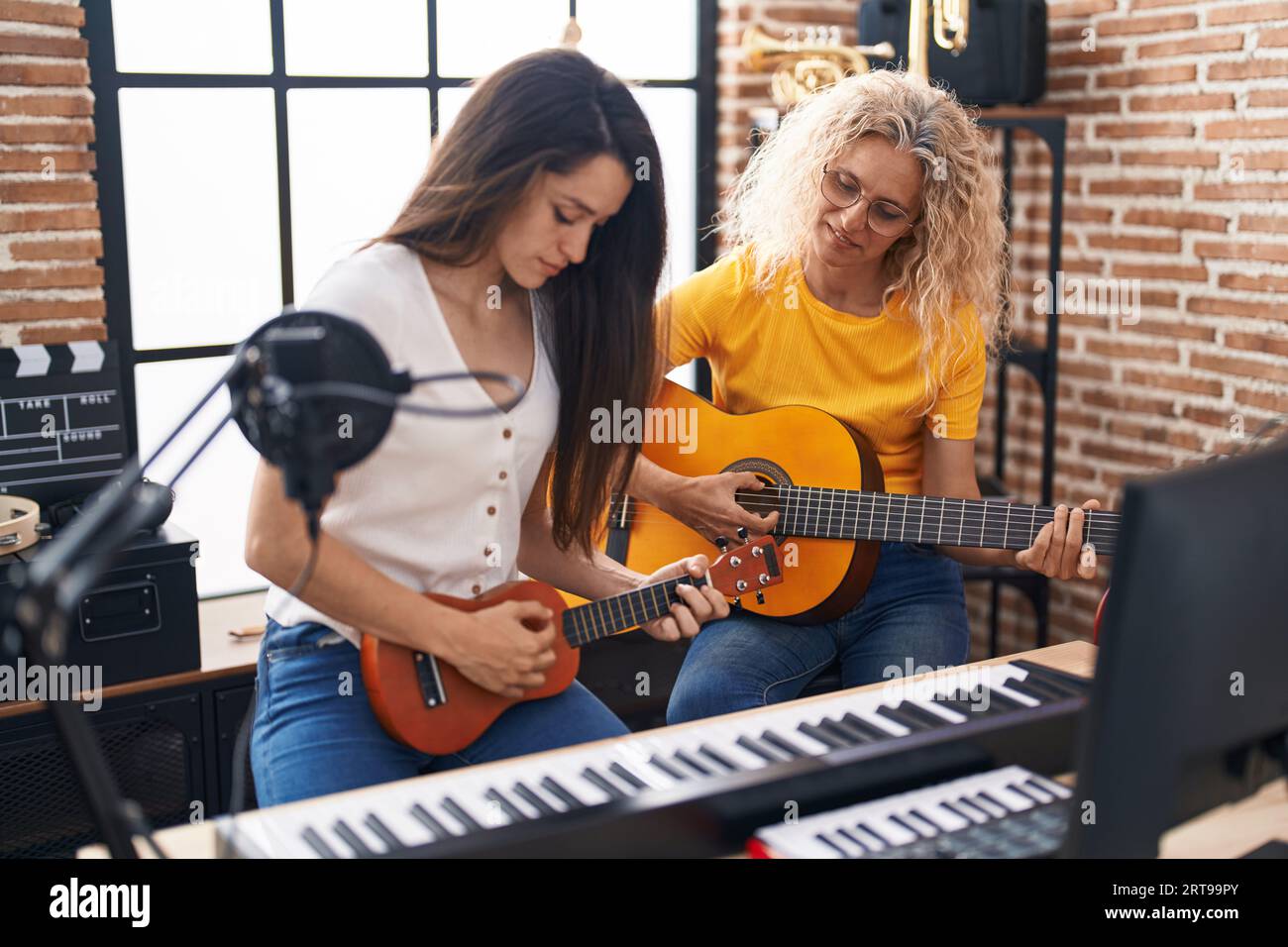 Two women musicians playing classical guitar and ukulele at music ...