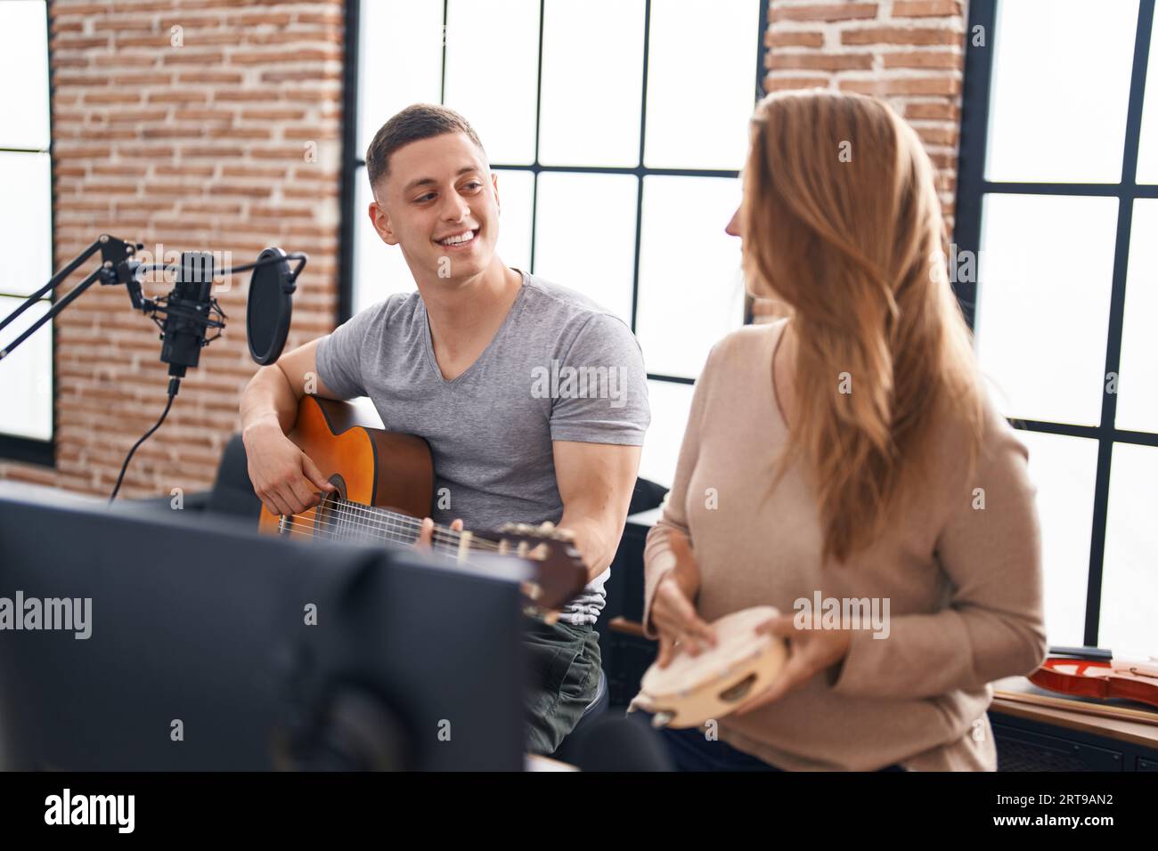Man and woman musicians playing classical guitar and tambourine at ...