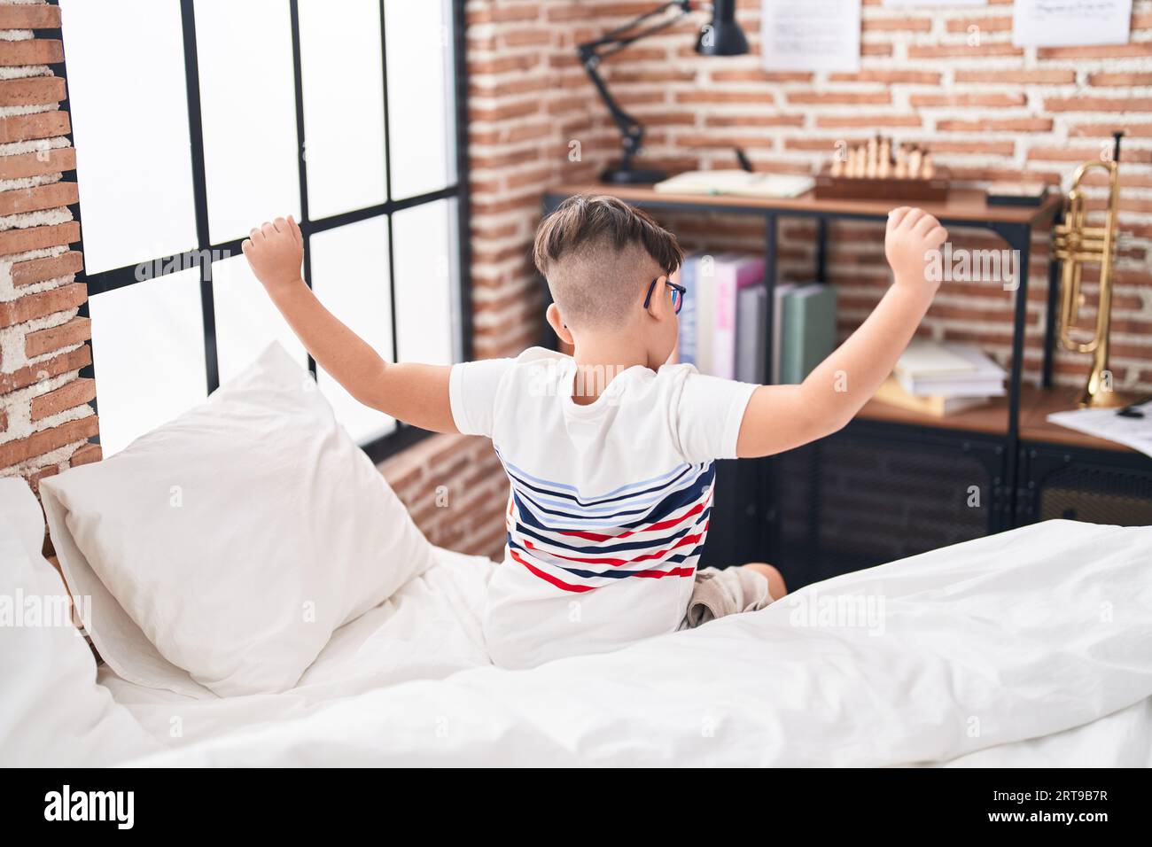 Adorable hispanic boy waking up stretching arms at bedroom Stock Photo - Alamy