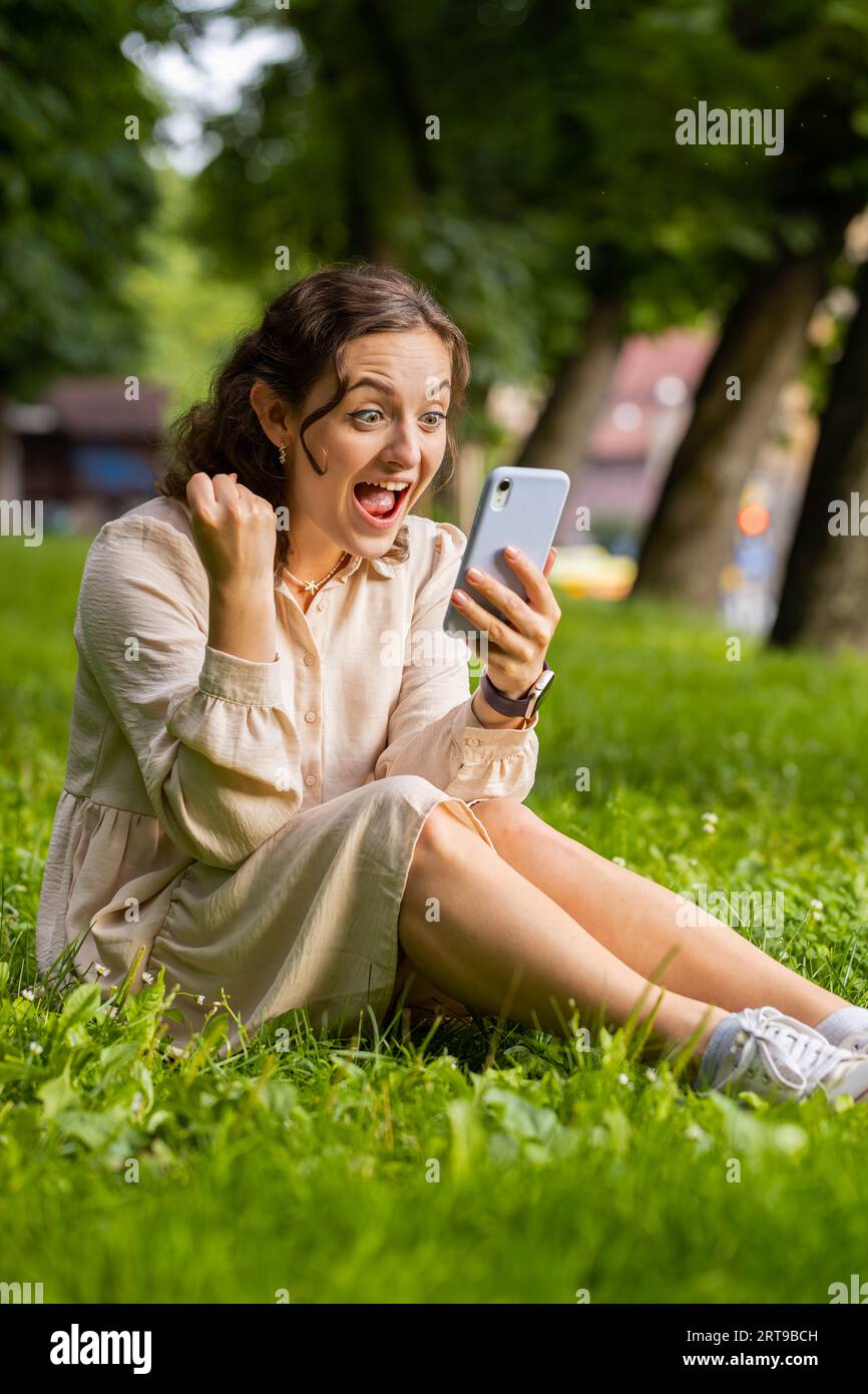 Young woman use mobile smartphone celebrating win good message news ...