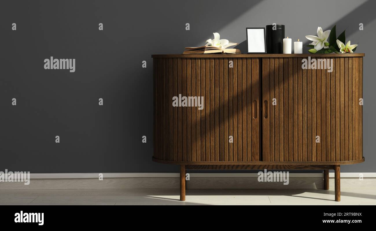 Mortuary urn with blank photo frame, glowing candles and lily flowers ...