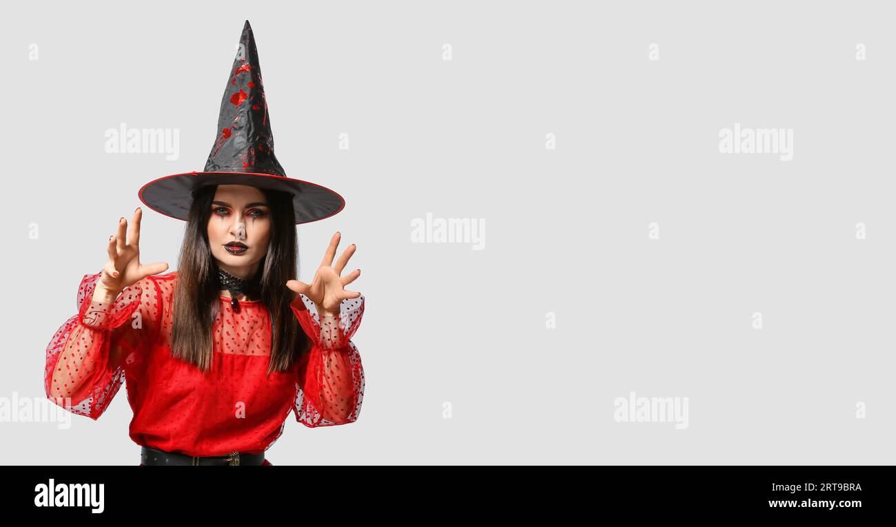 Beautiful woman dressed as witch for Halloween on light background with ...