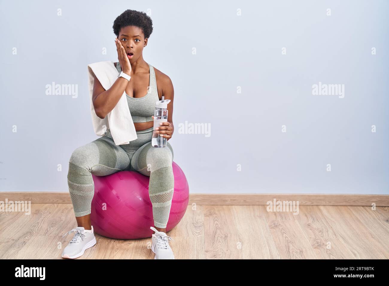 African american woman wearing sportswear sitting on pilates ball ...