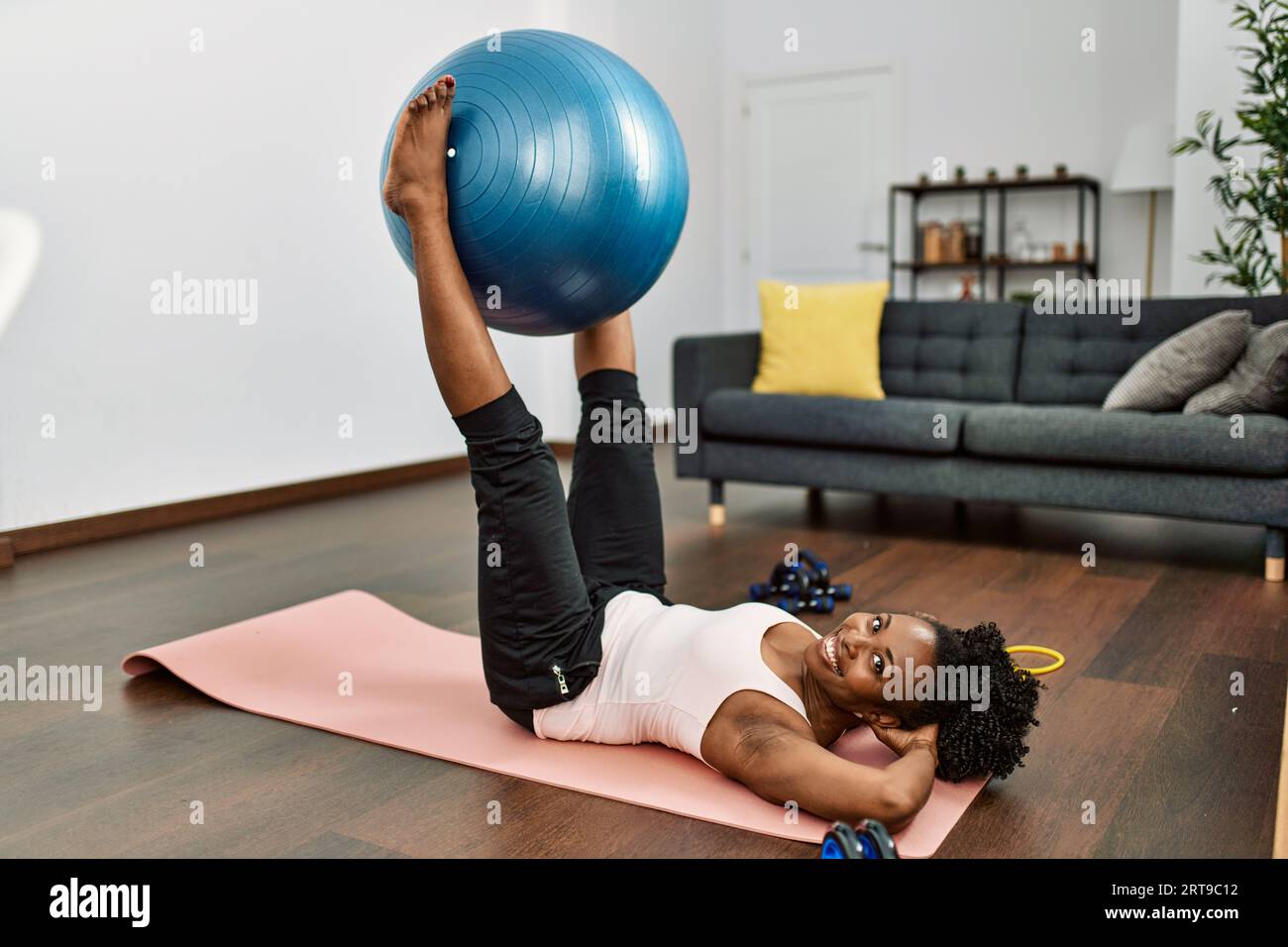 African american woman training abs exercise using fit ball at home ...