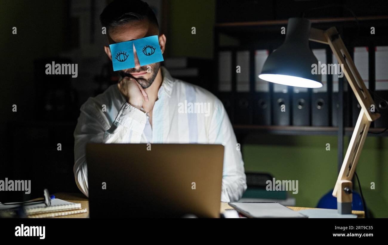 Young hispanic man business worker tired with reminders covering eyes ...