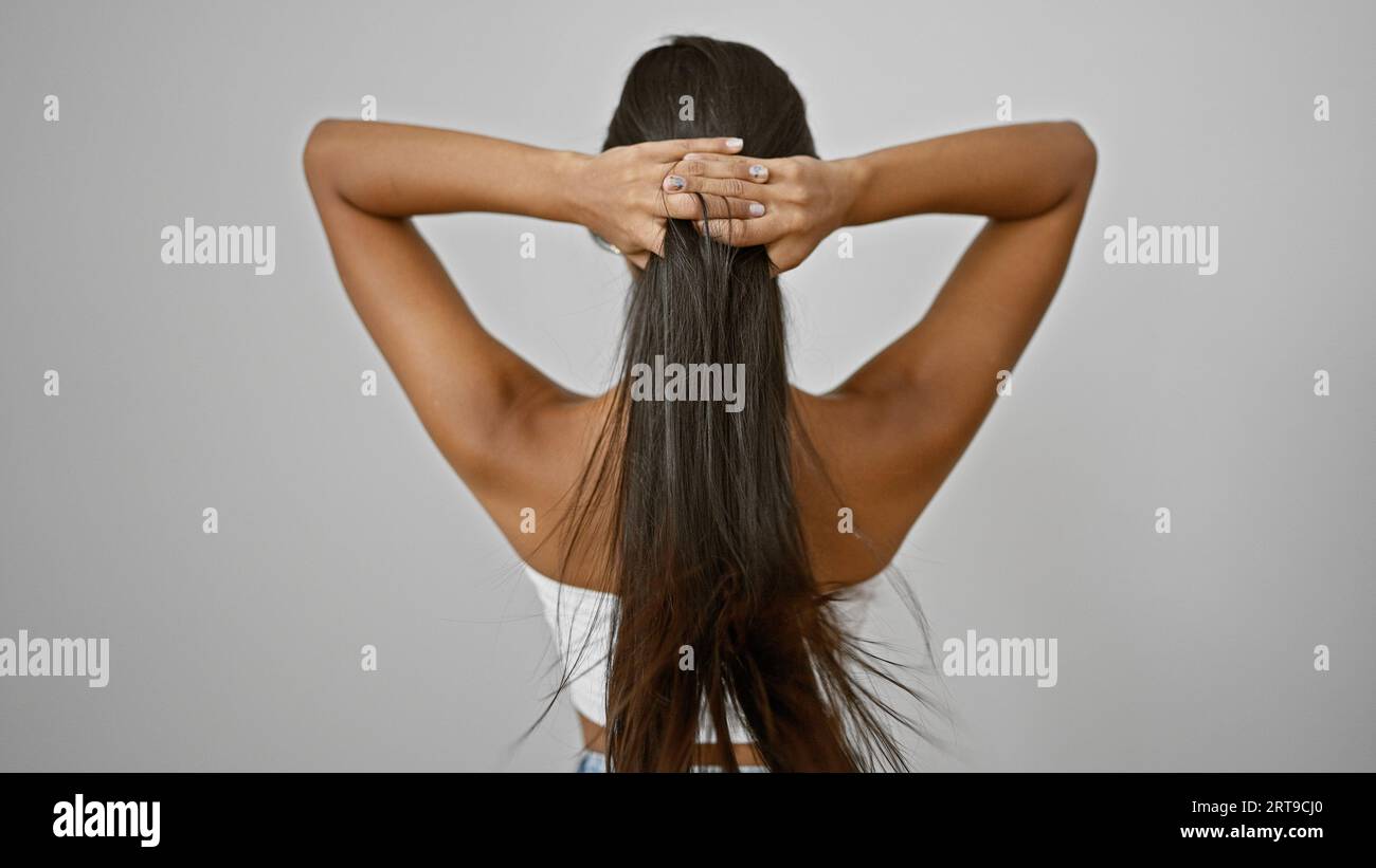 Young latin woman touching her hair backwards over isolated white ...
