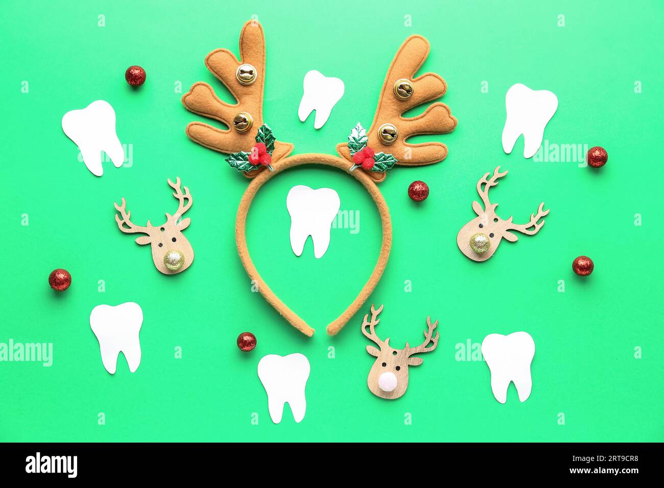 Reindeer horns with paper teeth and Christmas toys on green background ...