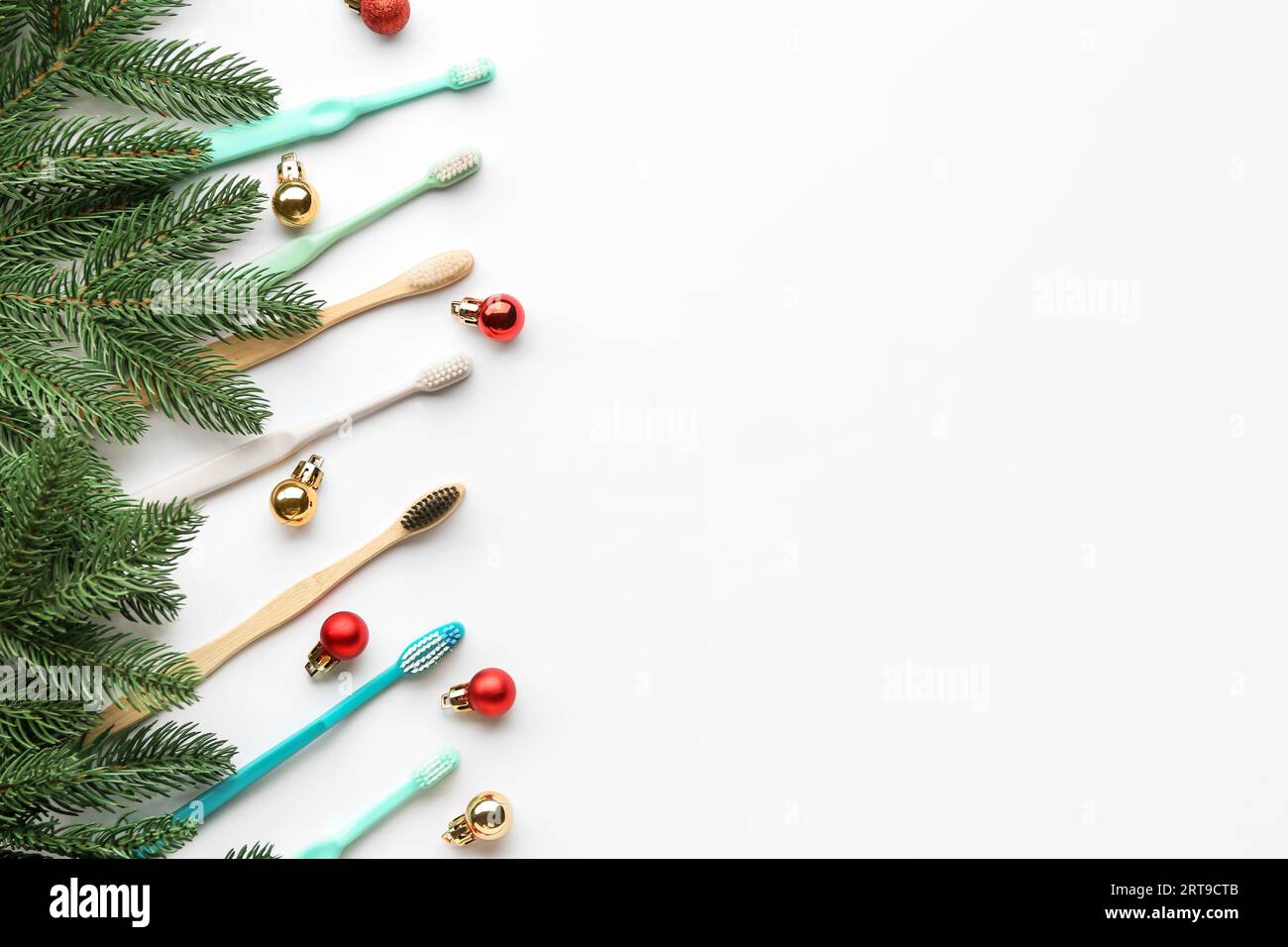 Toothbrushes with Christmas balls and fir branches on white background ...