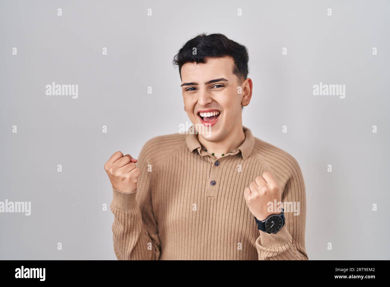 Non binary person standing over isolated background very happy and ...