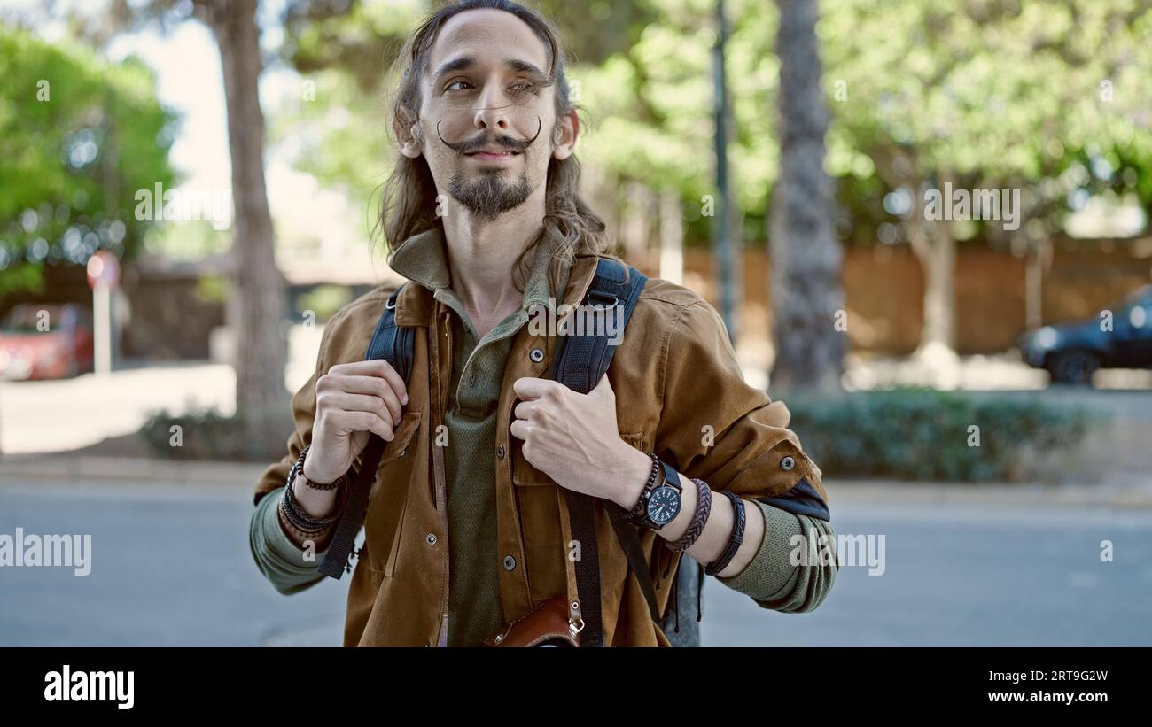 Young hispanic man tourist wearing backpack relaxed at park Stock Photo ...