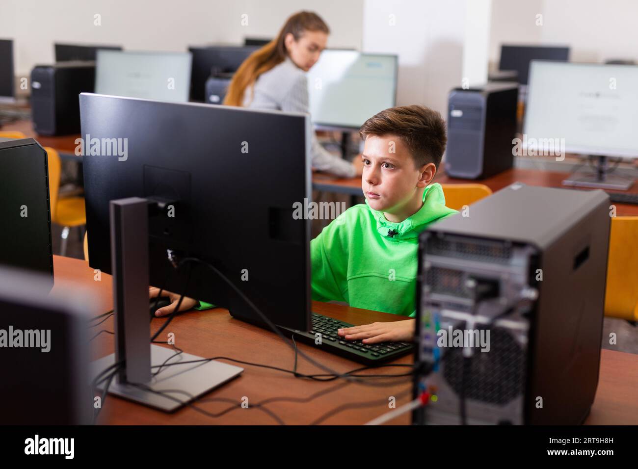 Schoolboy using PC during computer science lesson Stock Photo - Alamy