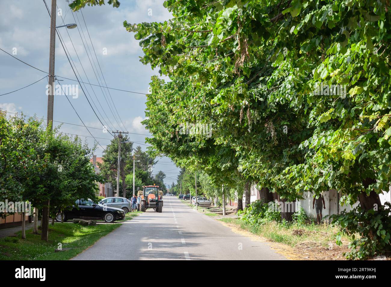 Picture of a tractor parked next to a street in spring in a small ...