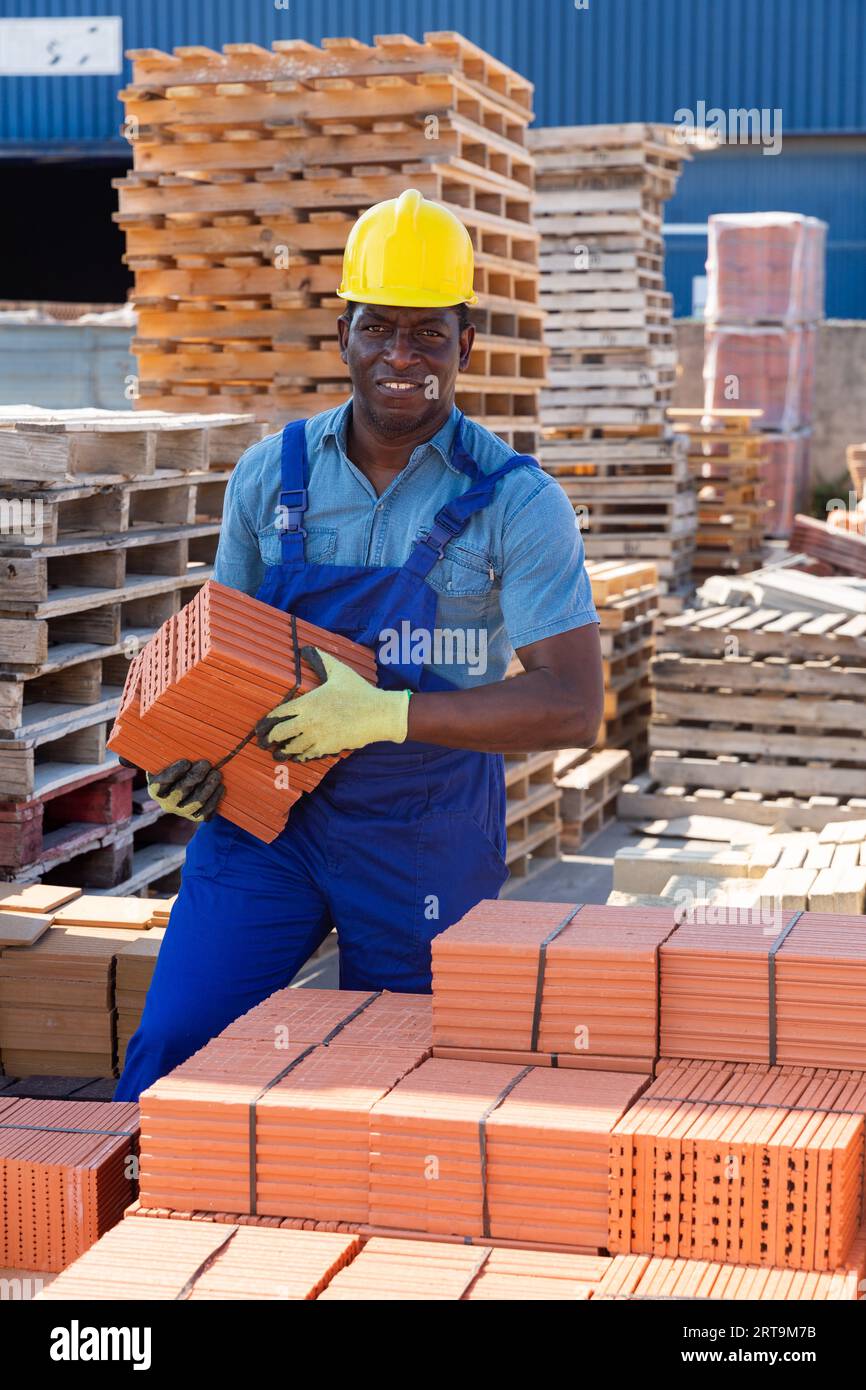 Worker stacking bricks in warehouse of building materials clpseup Stock ...