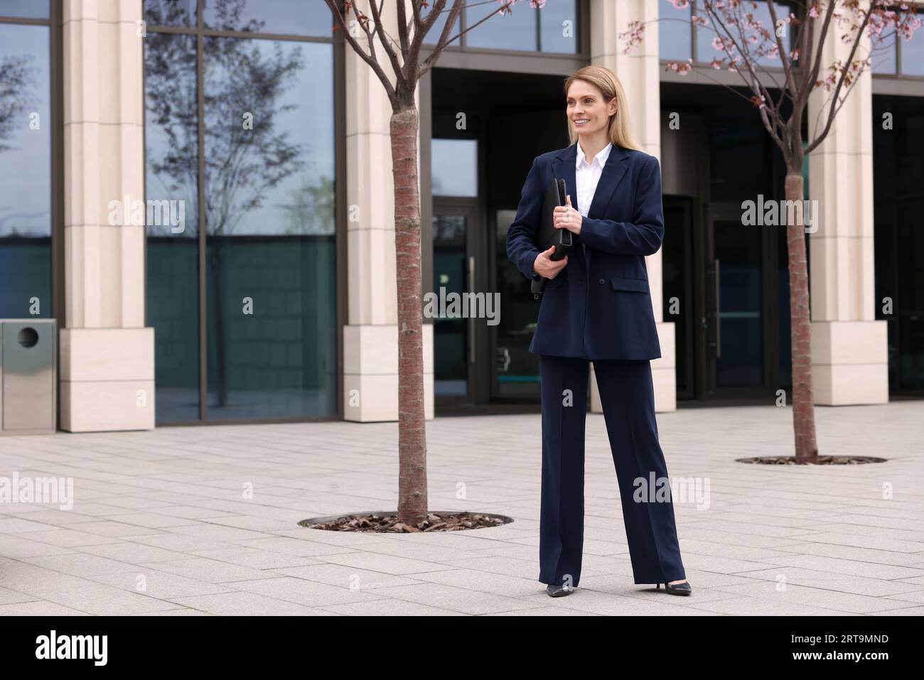 Female real estate agent with leather portfolio outdoors Stock Photo ...
