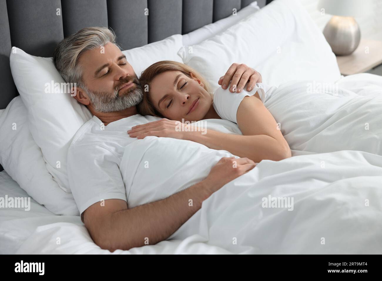Lovely mature couple sleeping together in bed at home Stock Photo - Alamy