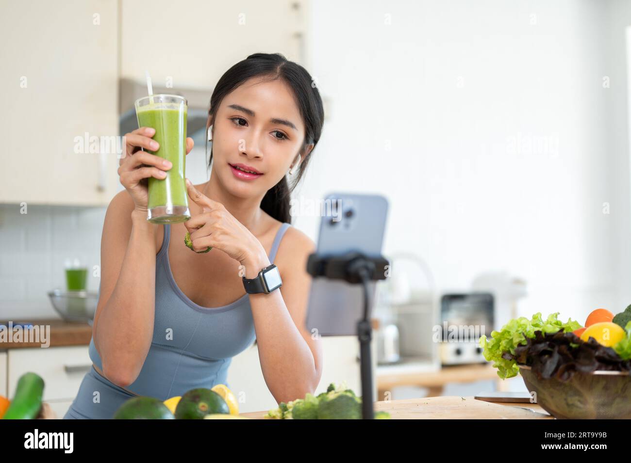 A beautiful and slim Asian female blogger or influencer in gym clothes ...