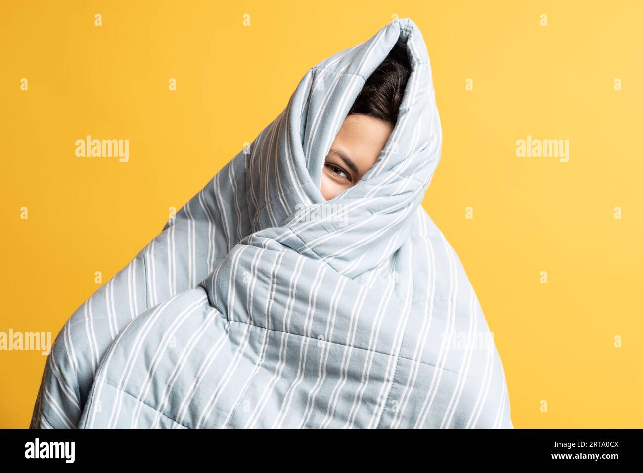 Teenager girl wrapped in looks out with one eye feeling comfort on ...